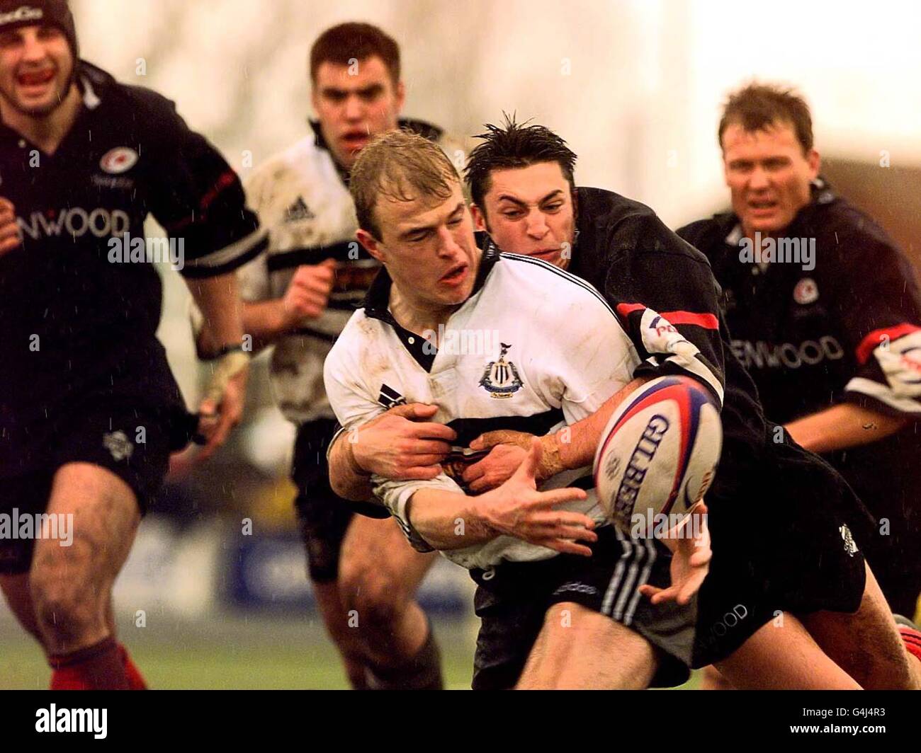 Martin Shaw of Newcastle Falcons (in white) is stopped by Rob Thirlby ...