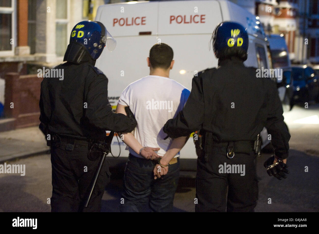 Police officers detain a 22-year-old man, wanted for violent disorder ...