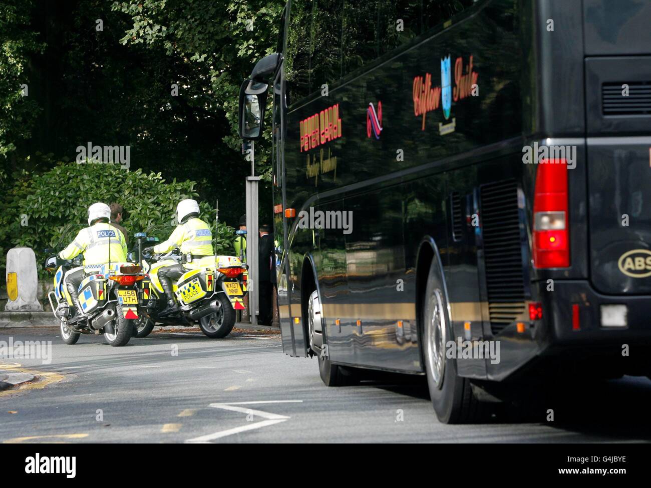 Joanna Yeates murder. Police outriders with a coach that was used to ...