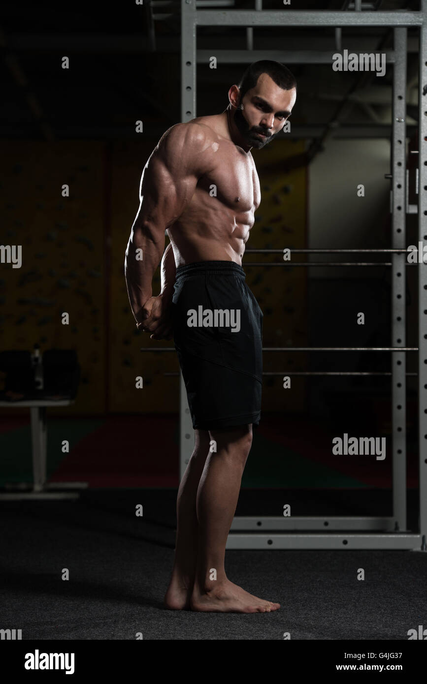 Young Man Standing Strong In The Gym And Flexing Side Triceps Pose ...