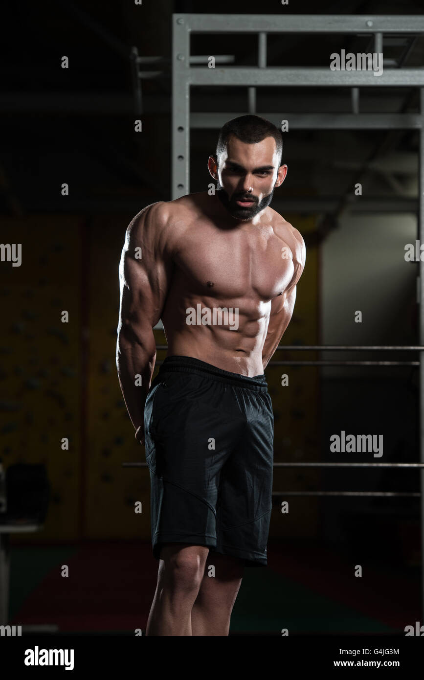 Young Man Standing Strong In The Gym And Flexing Side Triceps Pose ...