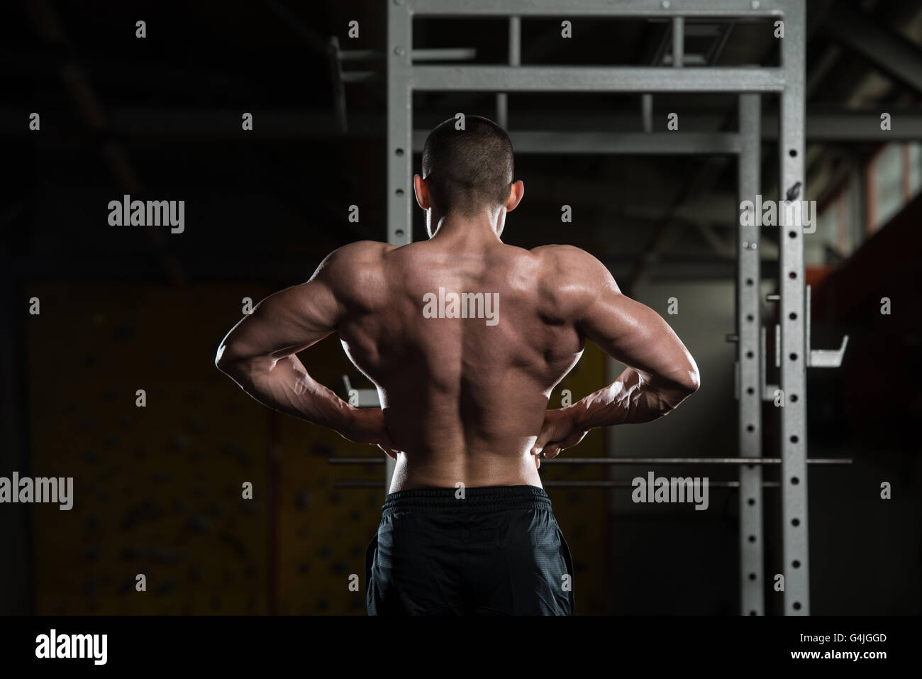 Young Man Standing Strong In The Gym And Flexing Rear Lat Spread Pose ...
