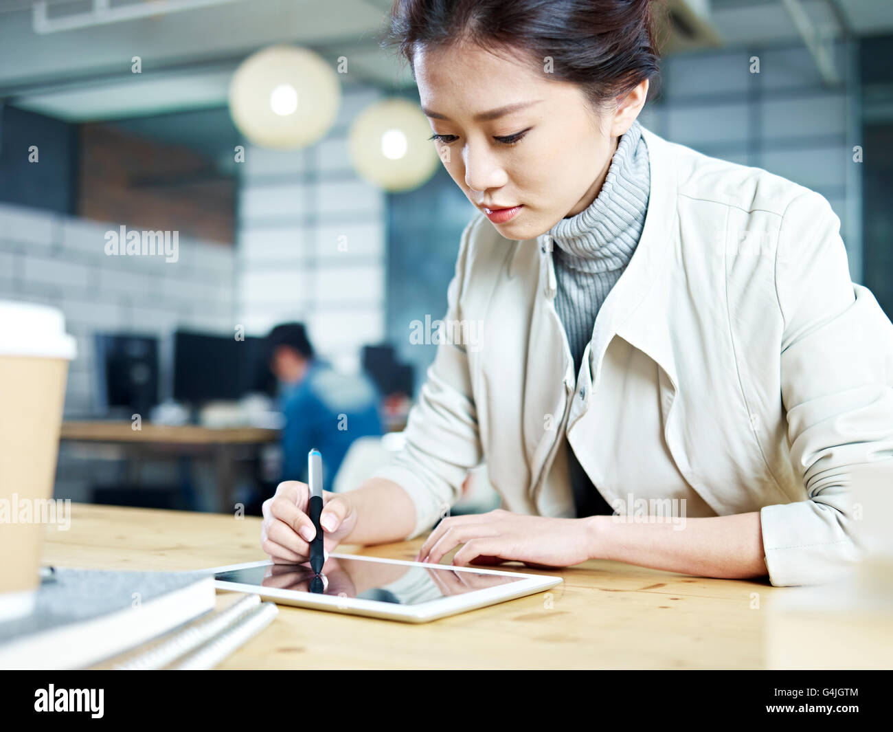 young asian designer working in studio using digital drawing pen and ...
