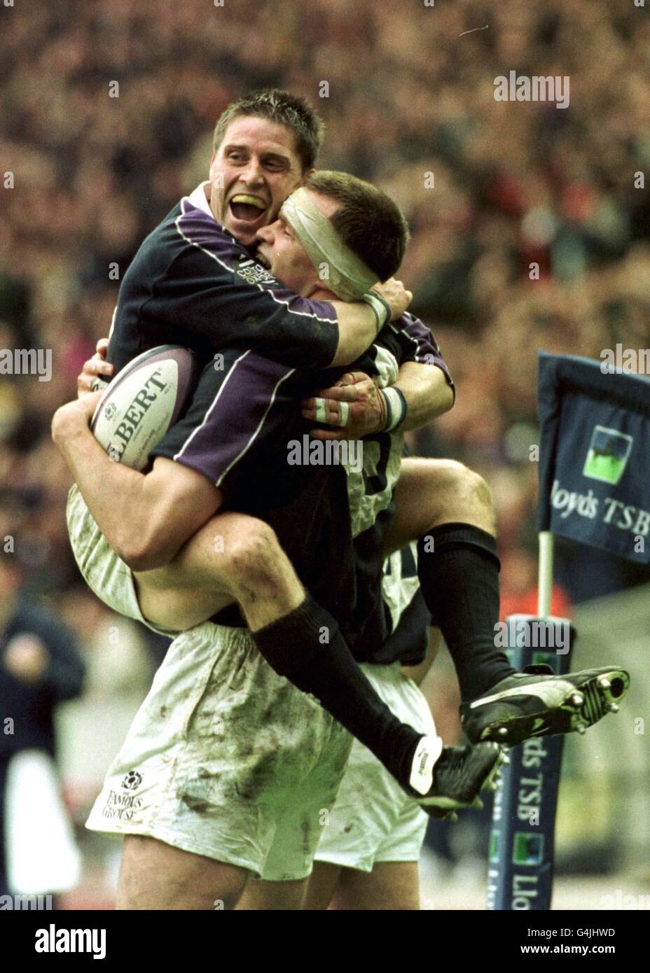 Scotland's Stuart Grimes holds up team-mate Alan Tait after scoring a ...