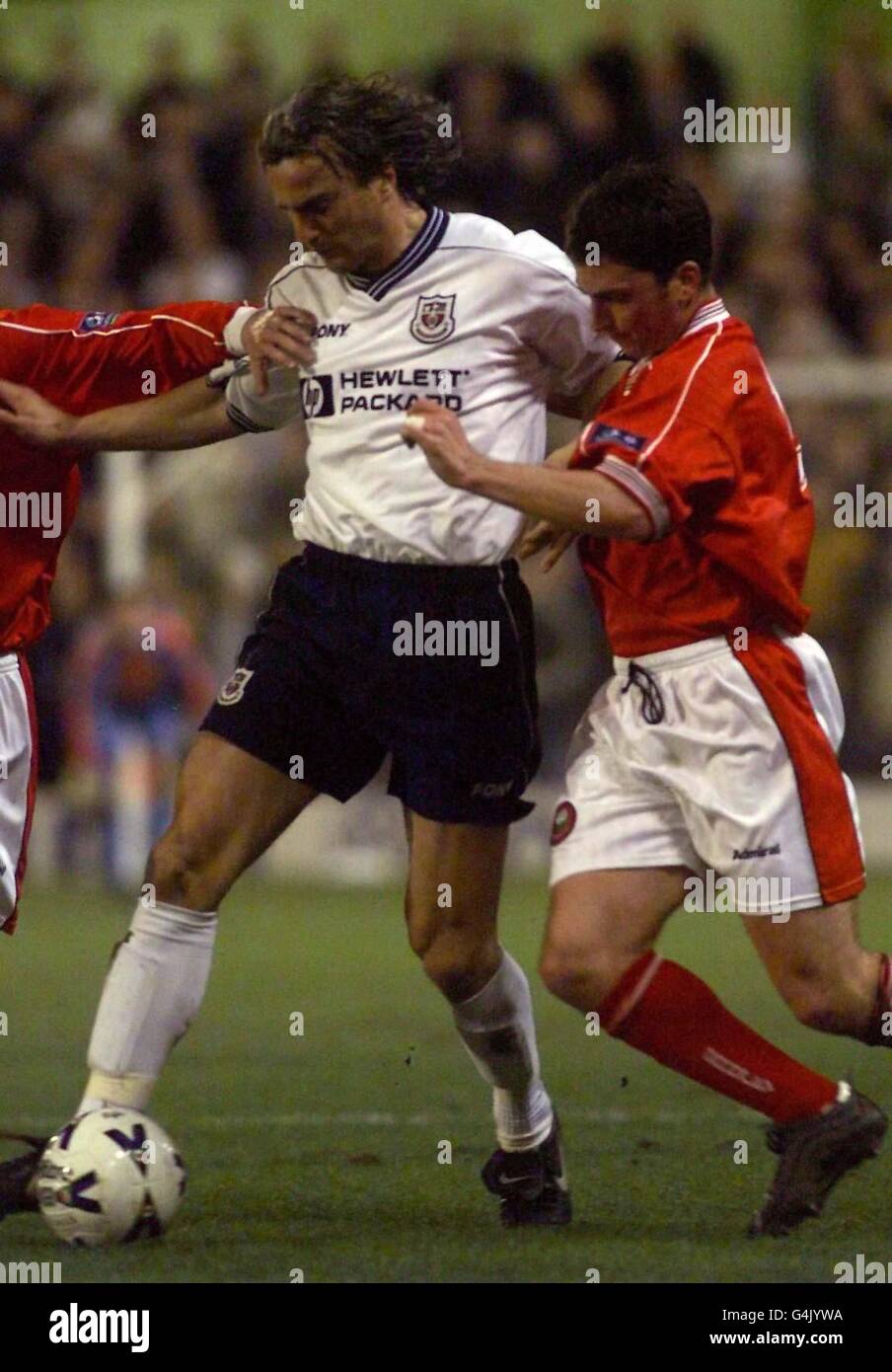 Tottenham's David Ginola (centre) is held back by Barnsley's Nicky ...