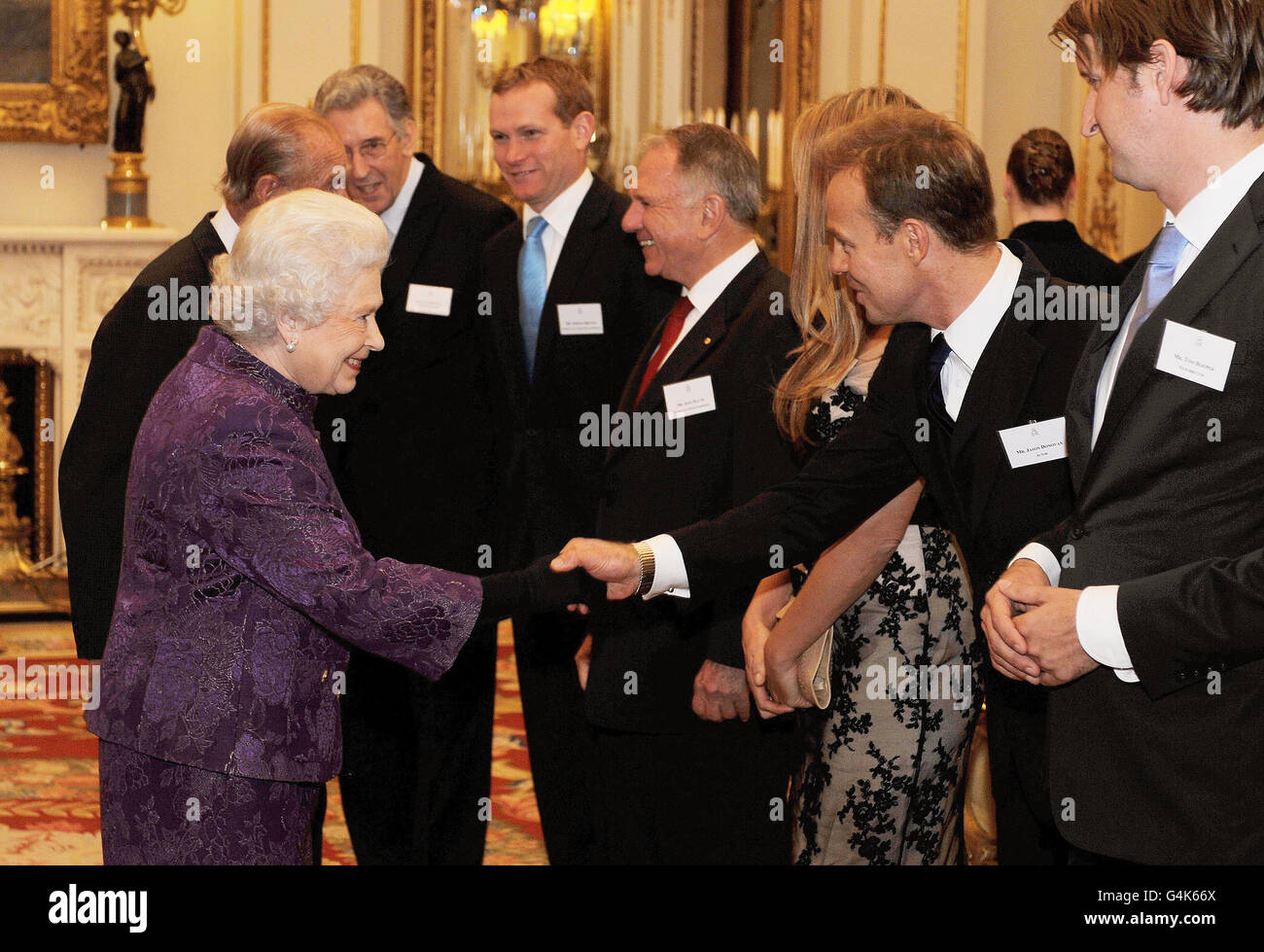 Queen Elizabeth II shakes hands with Jason Donovan in the white drawing ...