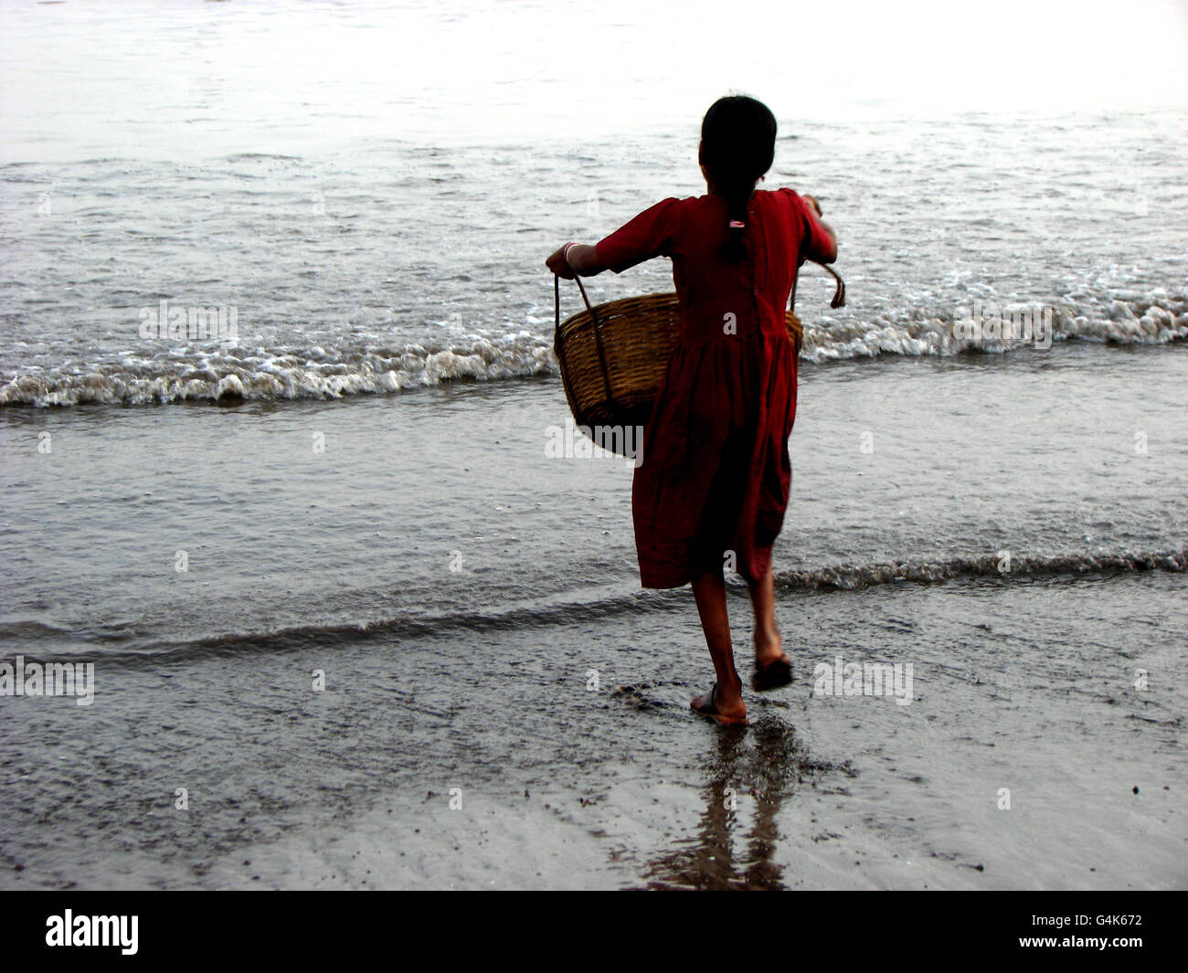 Fishergirl washing her catch of crabs in the sea Stock Photo - Alamy