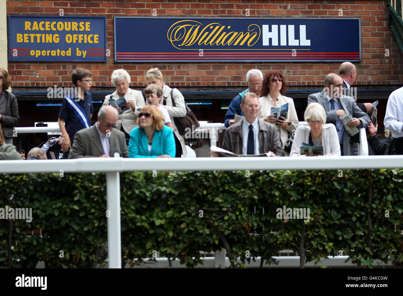 Spectators look at their racecards before the days action Stock Photo ...