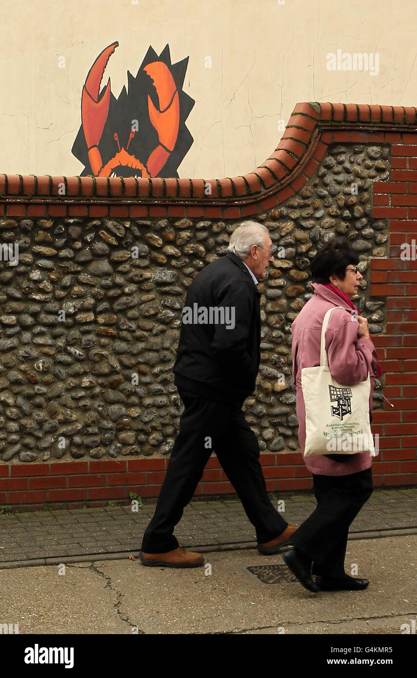 People pass by a mural of a crab in the seaside town of Cromer on the ...