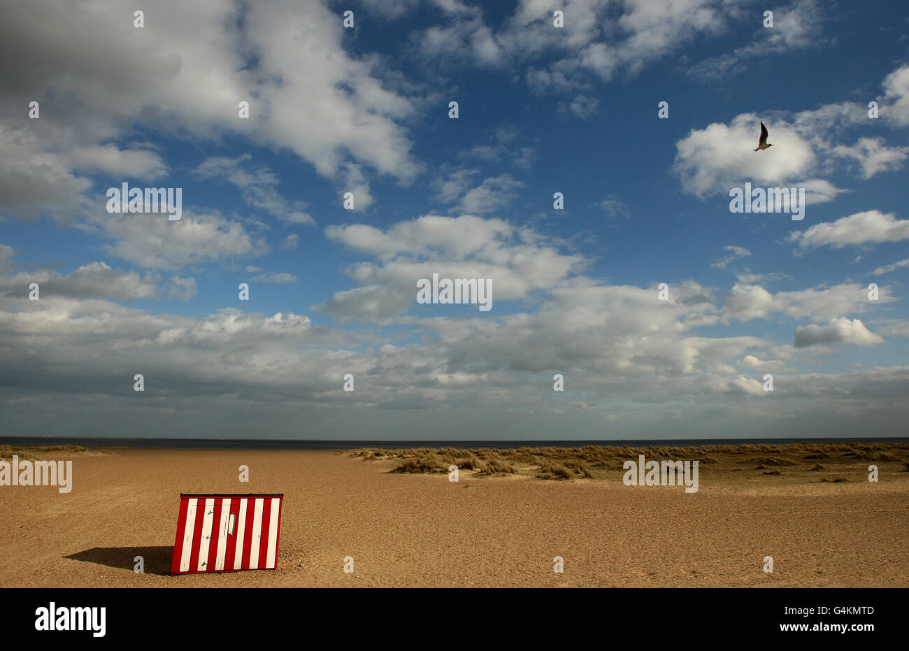 A beach hut stands on an empty beach in the Norfolk seaside town of ...