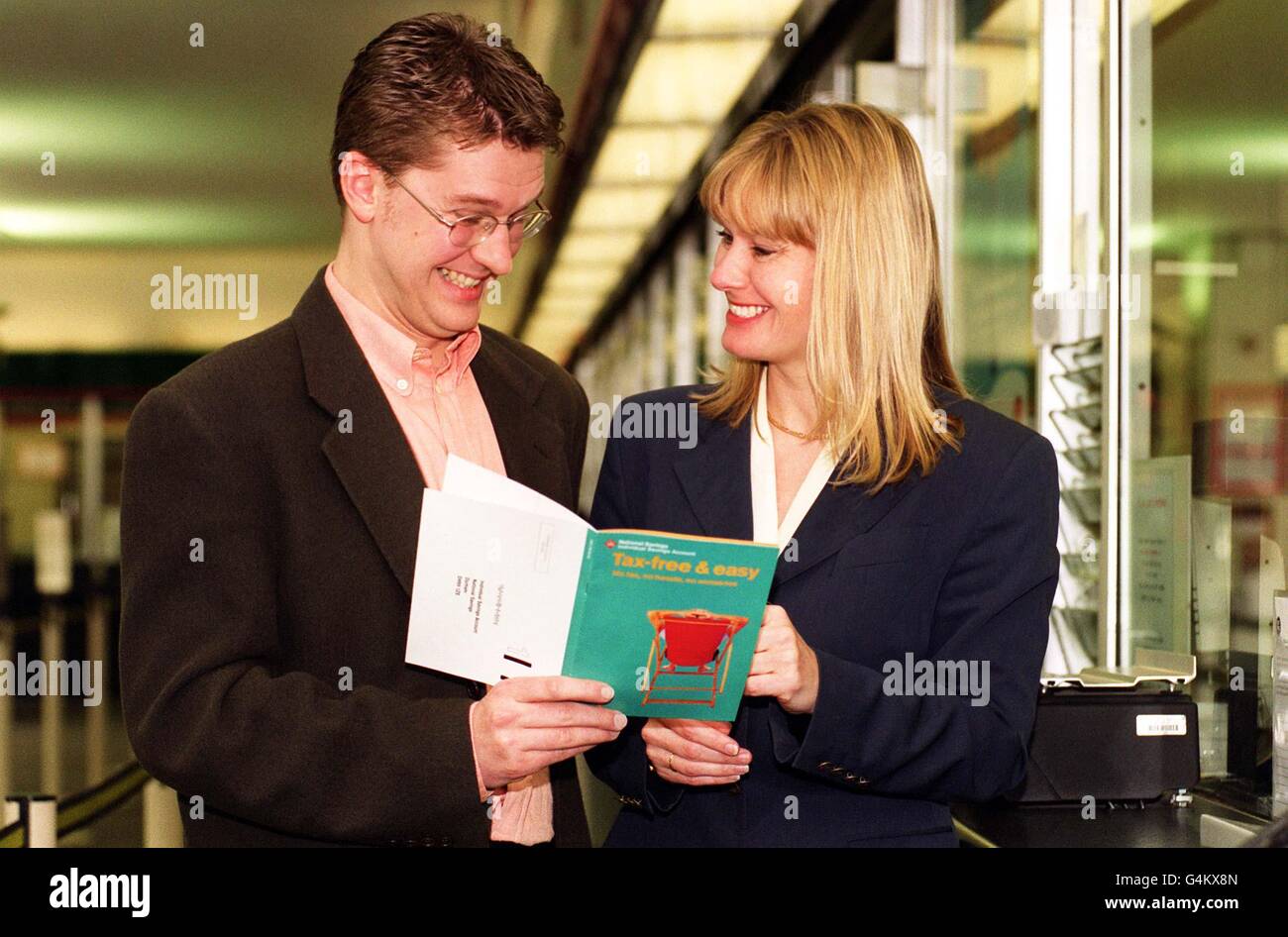 Pascal Don (L) goes through the brochure for the new National Savings ...