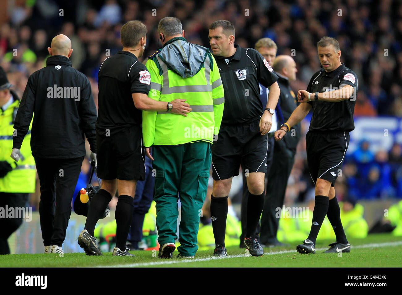 Referee Mark Halsey (right) looks at his watch as Fourth Official Phil ...