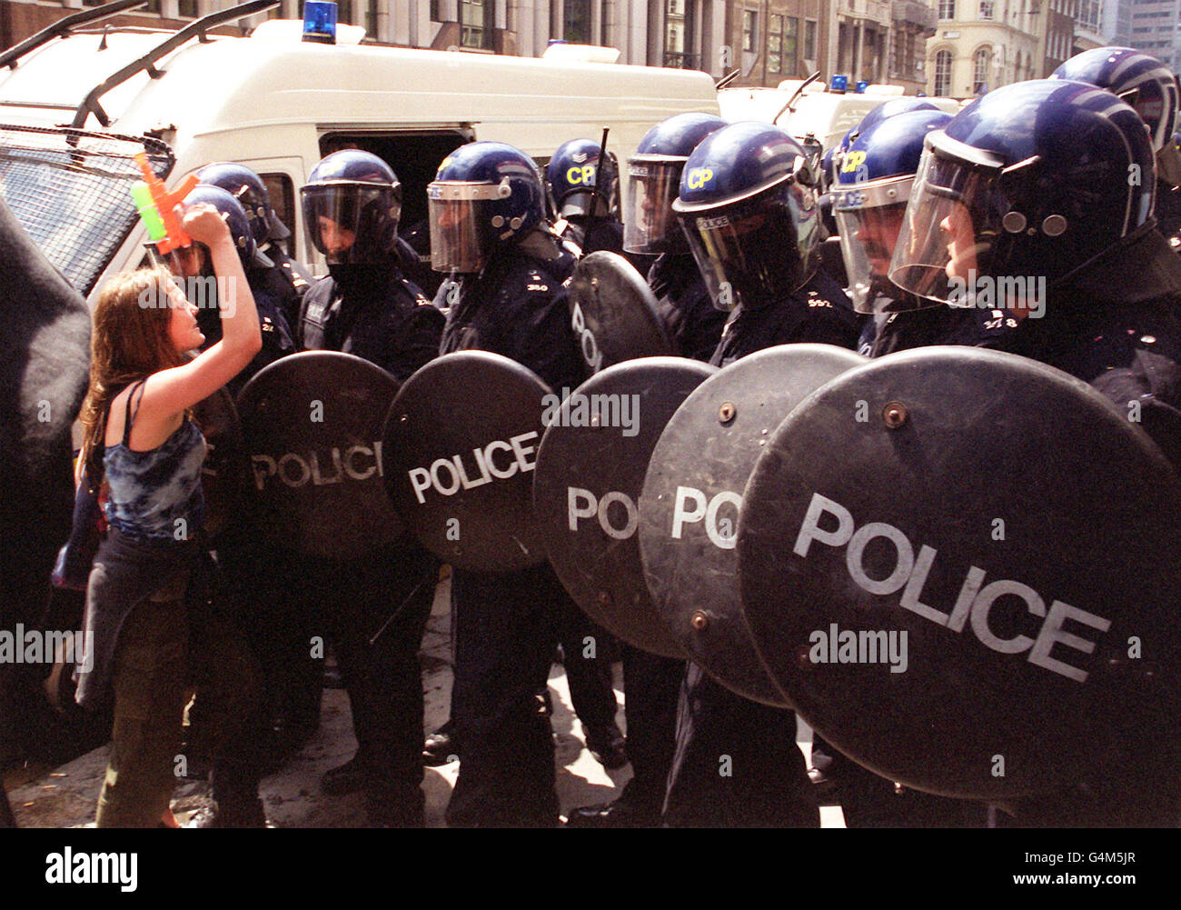 Police in riot gear confront an angry demonstrator at London Wall in ...
