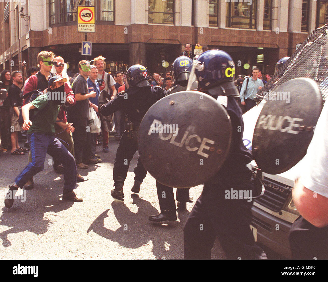 Police in riot gear confront angry demonstrators in the City of London ...