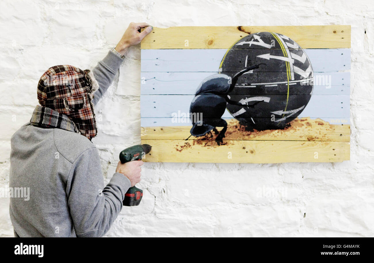 A curator hangs a stencil Lampooning the Naas Ball in the South Studios ...