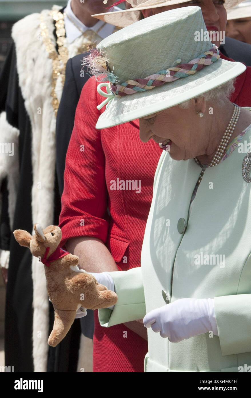 Queen Elizabeth II is given a stuffed toy animal while meeting crowds ...