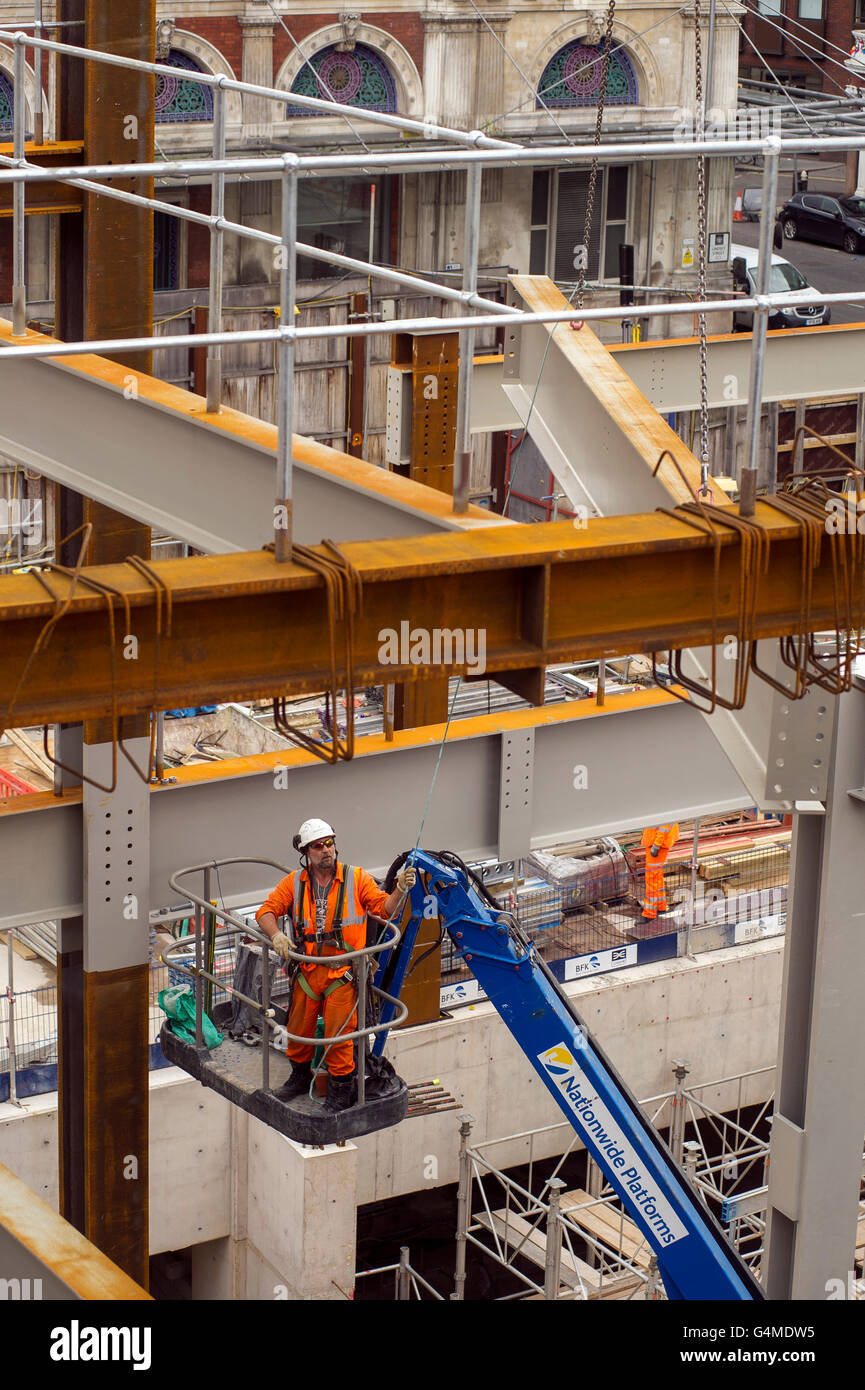 Construction worker in a hoist installing girders at the Eastern Ticket ...