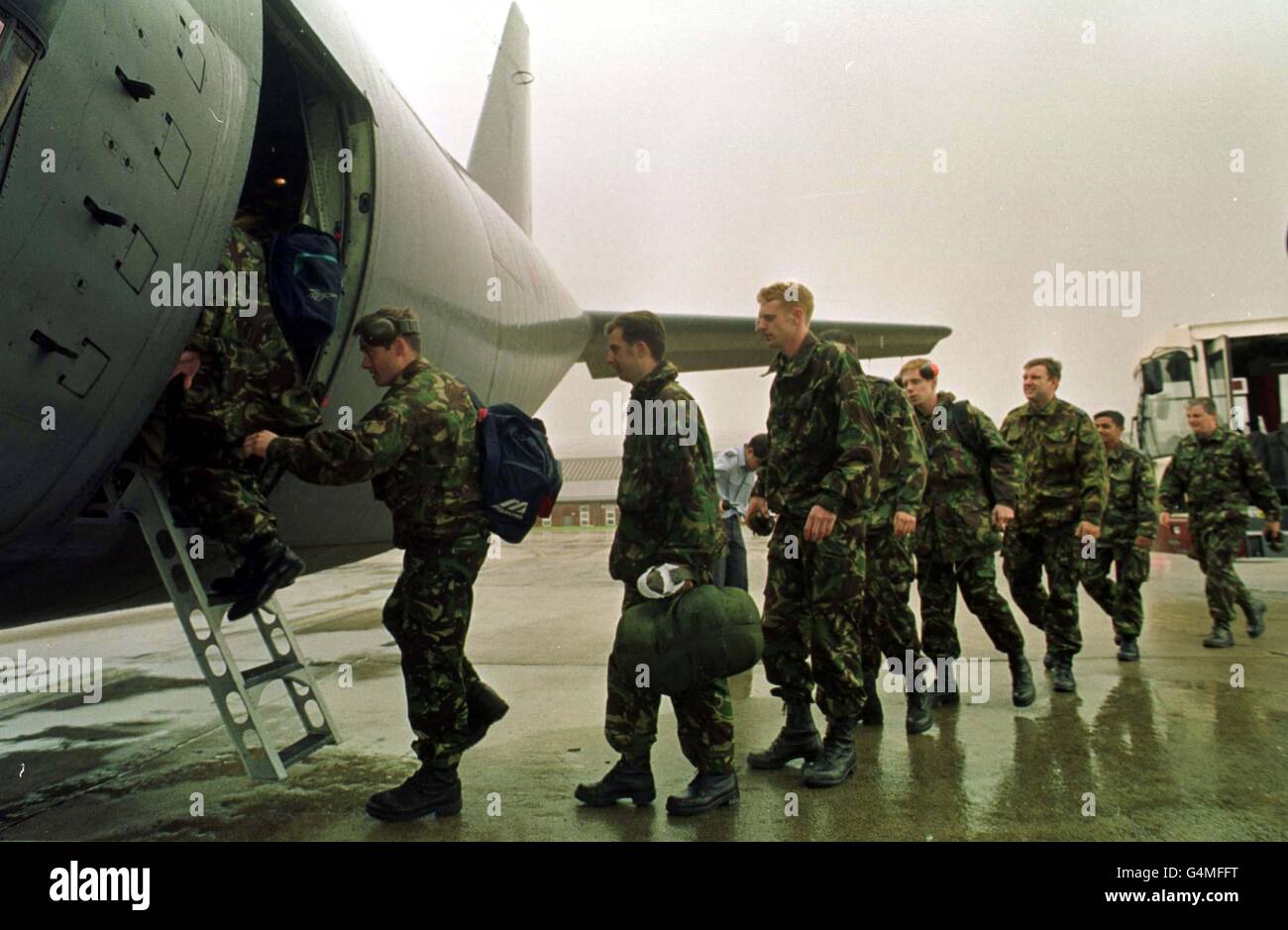Helicopter technicians board a raf hercules aircraft at raf lyneham hi ...