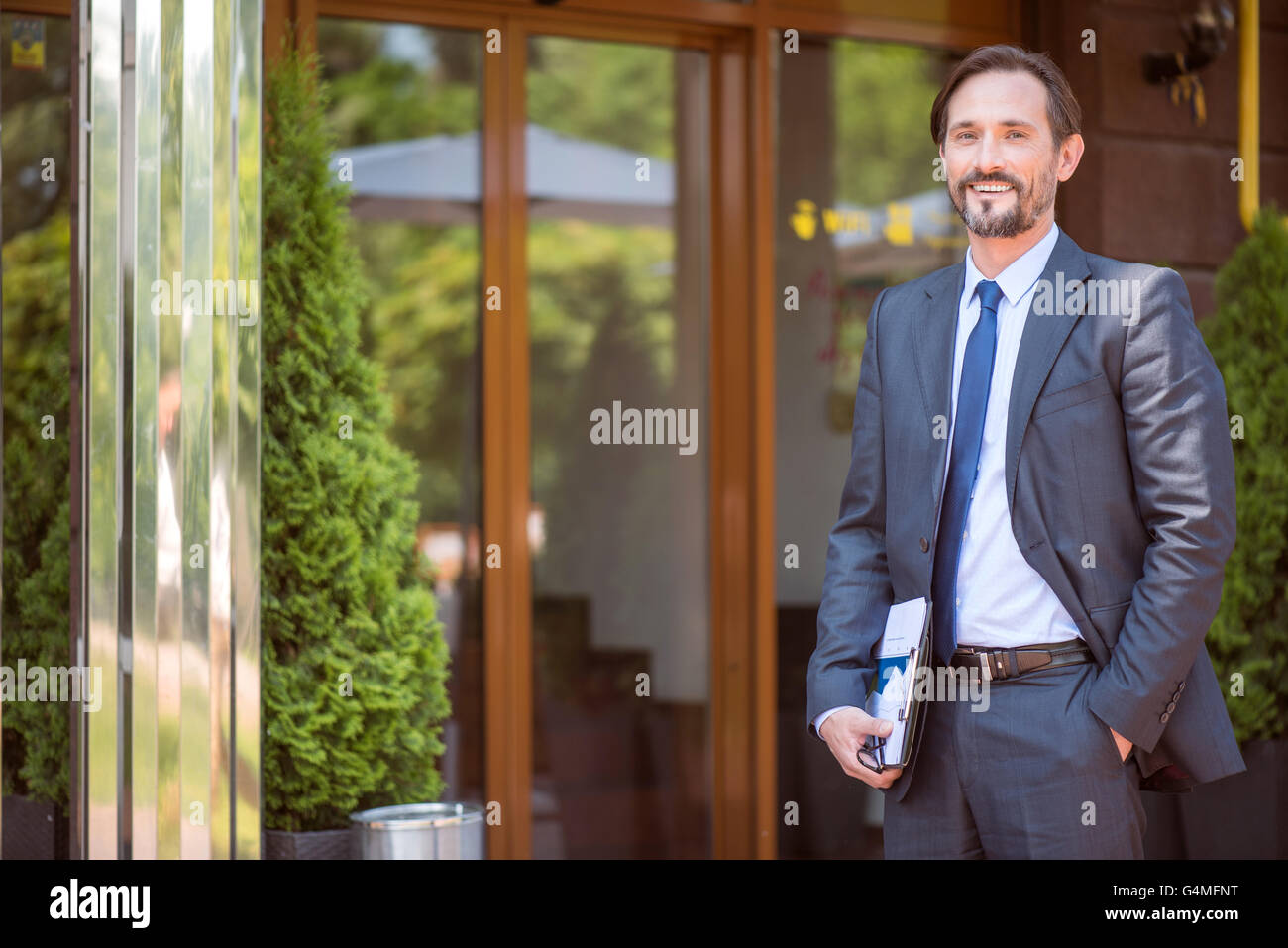 Handsome smiling man standing outside Stock Photo - Alamy