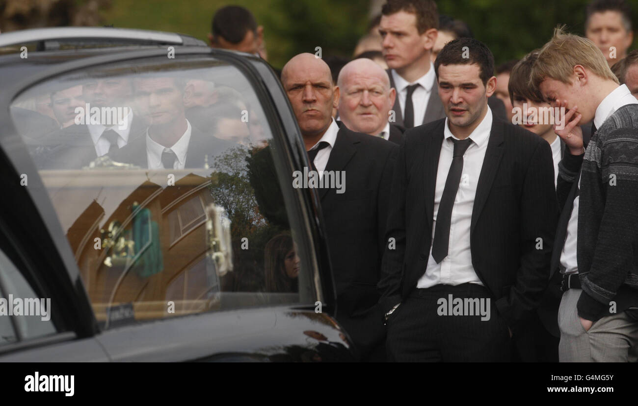 Mourners look on as the coffins of Bridget Sharkey and her brother ...