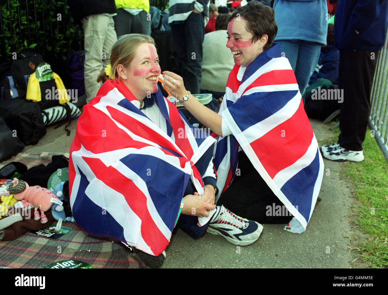 No commercial use. Tennis fans, Emma Tytherleigh (L) has her face ...