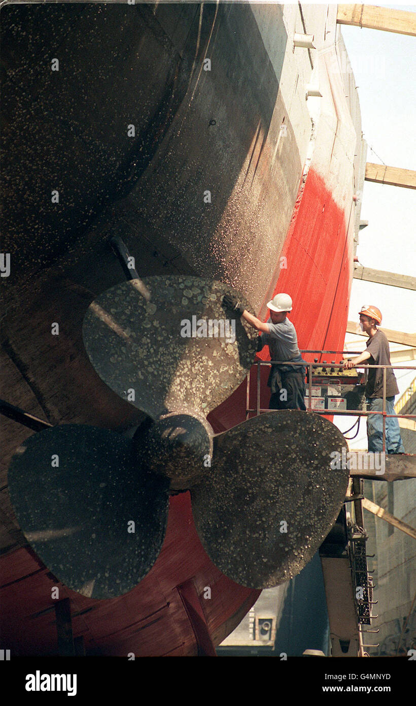 A worker checks the propeller on the cruiser HMS Belfast whilst it is ...