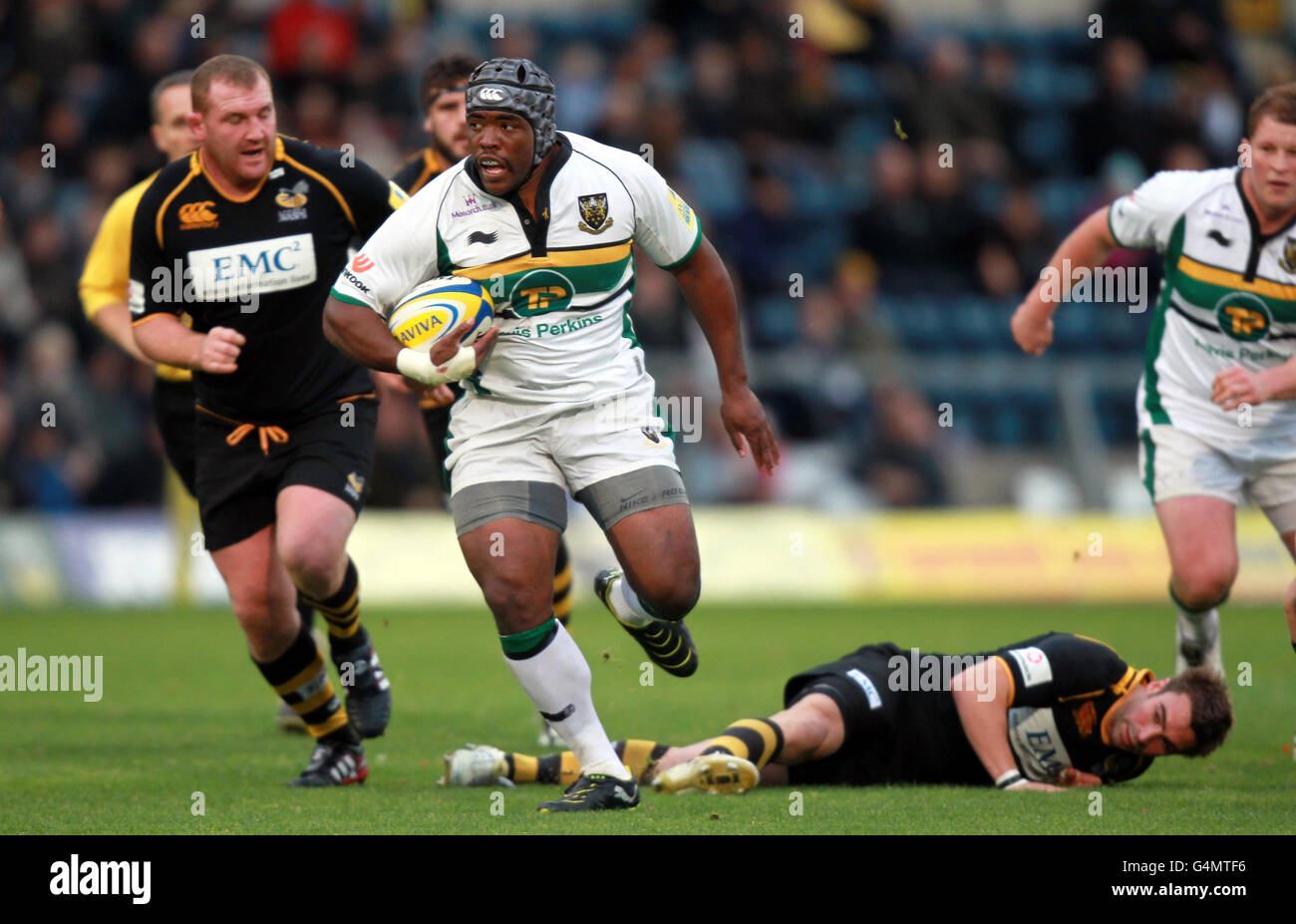 Northampton's Brian Mujati breaks through the tackle of Wasps Nicky ...