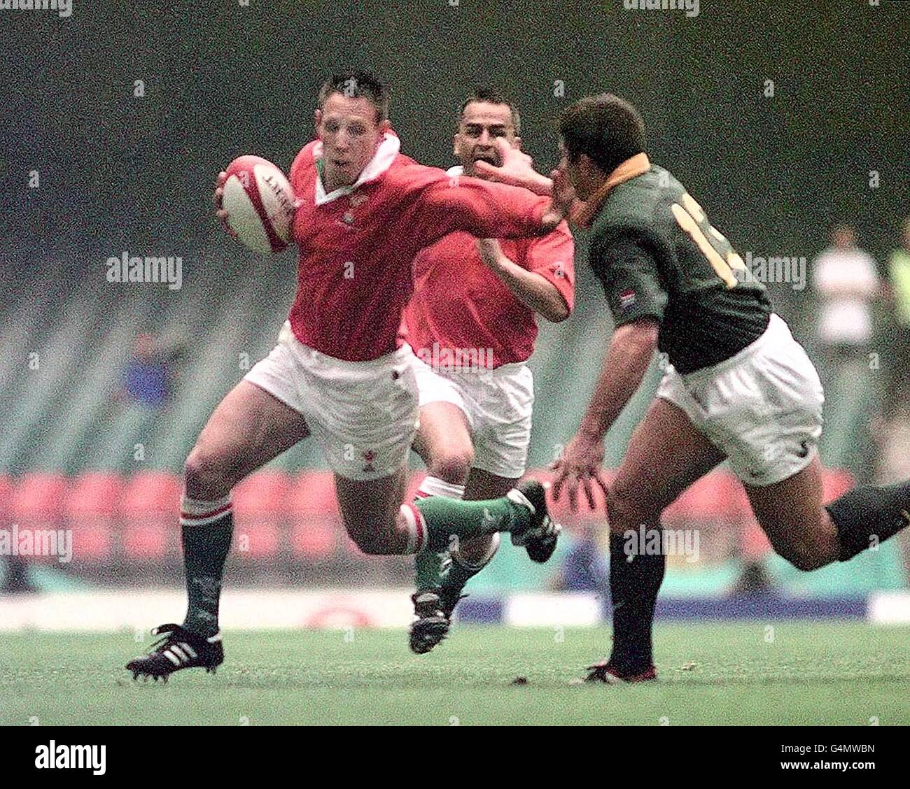 Wales' Mark Taylor (L) hands off South Africa's Pieter Muller to score ...