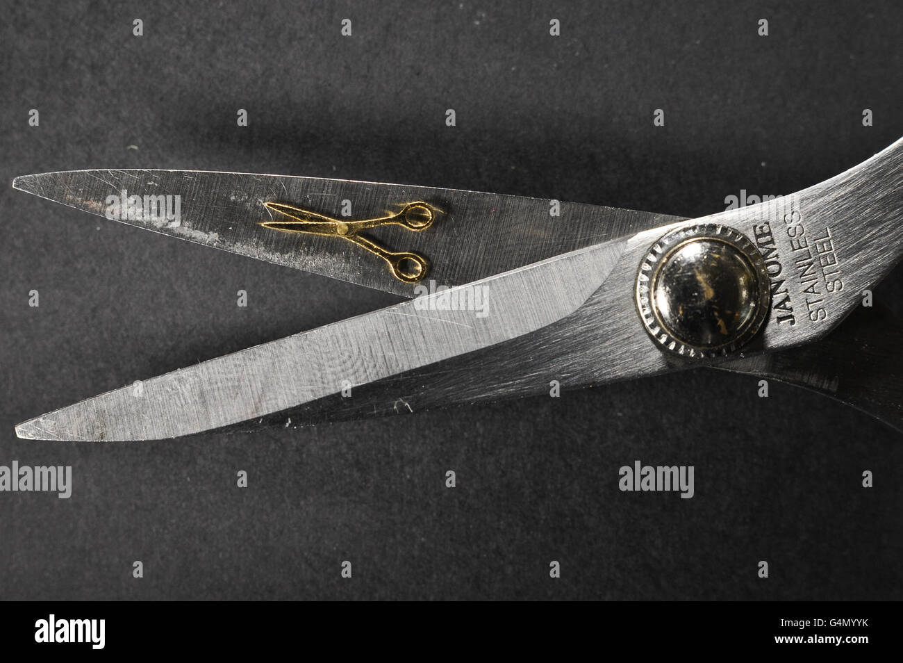 A tiny pair of all brass and fully working hinged scissors rest on the ...