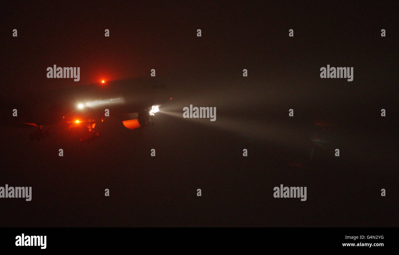 A plane lands in fog at Heathrow Airport after a number of flights were ...