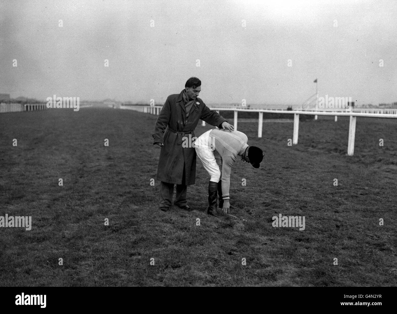 Devon Loch's disconsolate jockey Dick Francis is given a consoling pat ...