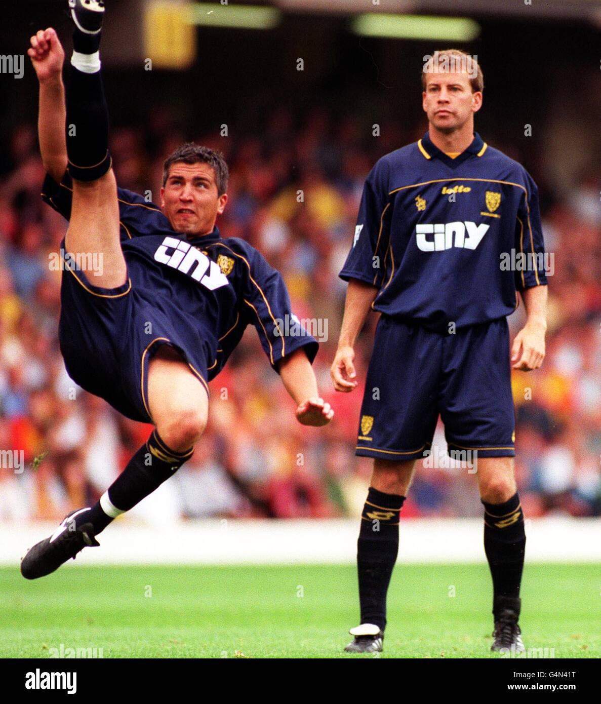 Wimbledon's Tore Pedersen looks on as his team-mate Andy Roberts clears ...