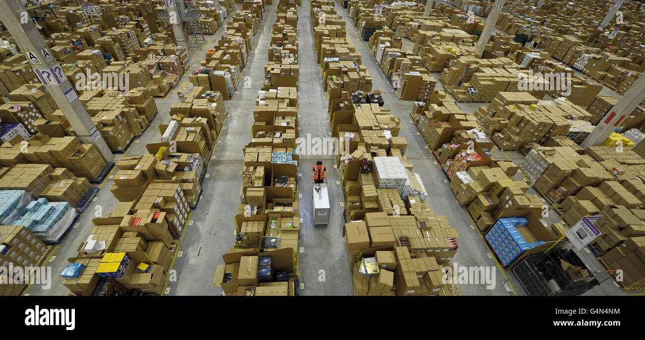 A worker at the Amazon fulfilment centre in Swansea pushes a picker ...