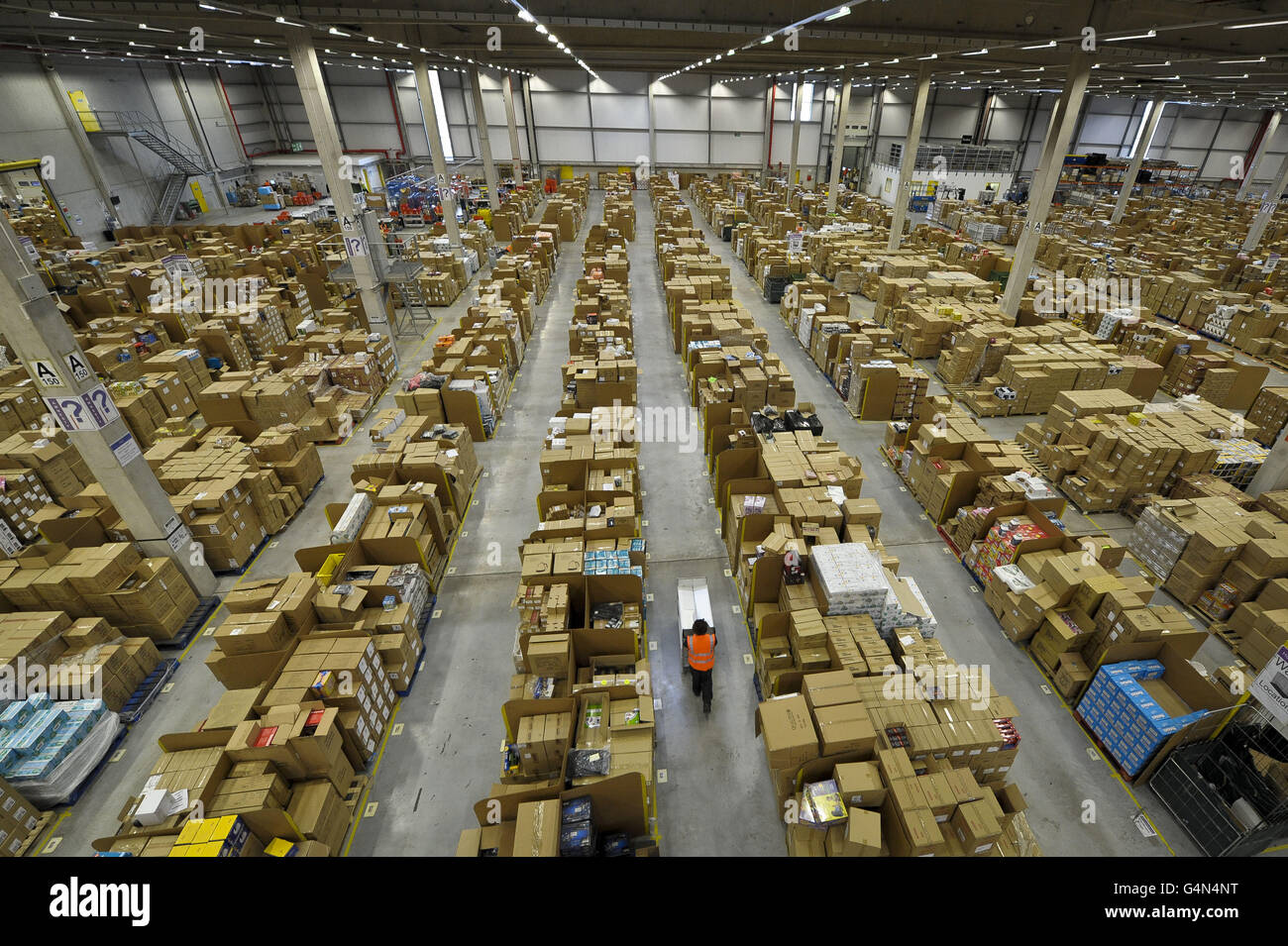 A worker at the Amazon fulfilment centre in Swansea pushes a picker ...