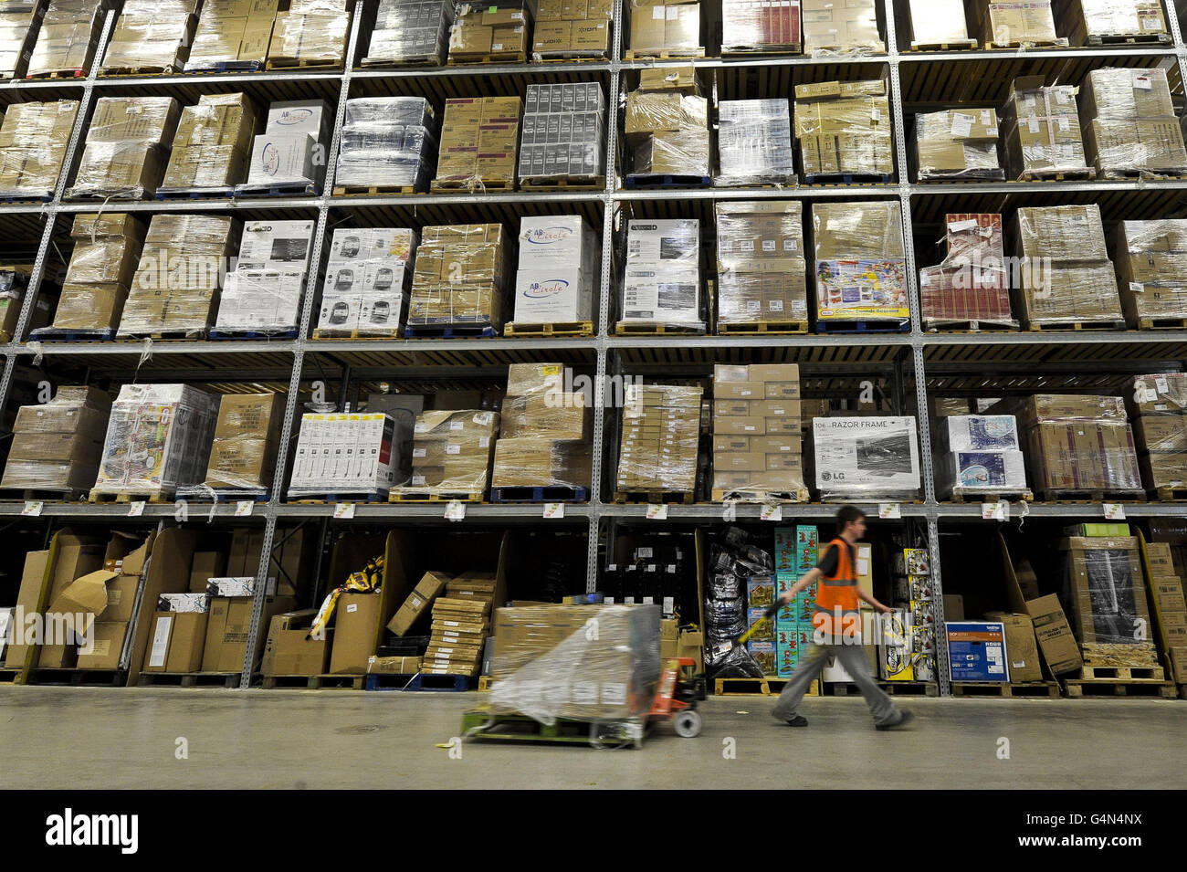A worker at the Amazon fulfilment centre in Swansea pushes a picker ...