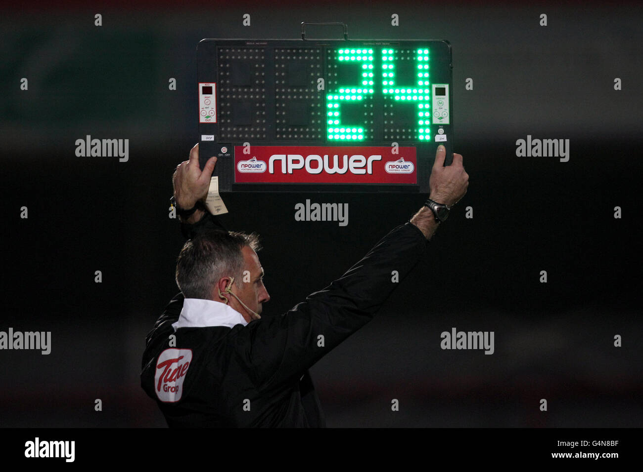The fourth official holds up the board hi-res stock photography and ...