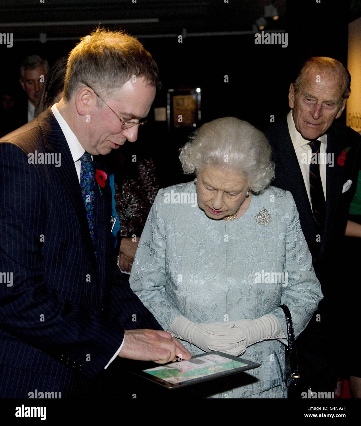 Queen Elizabeth II and the Duke of Edinbugh are shown an iPad app by ...