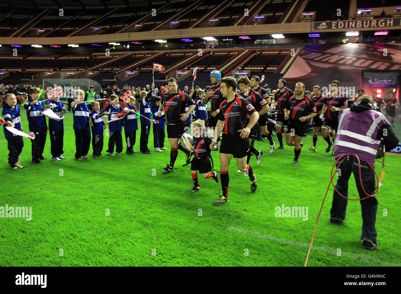 Edinburgh captain Greig Laidlaw and the matchday mascot lead out the ...
