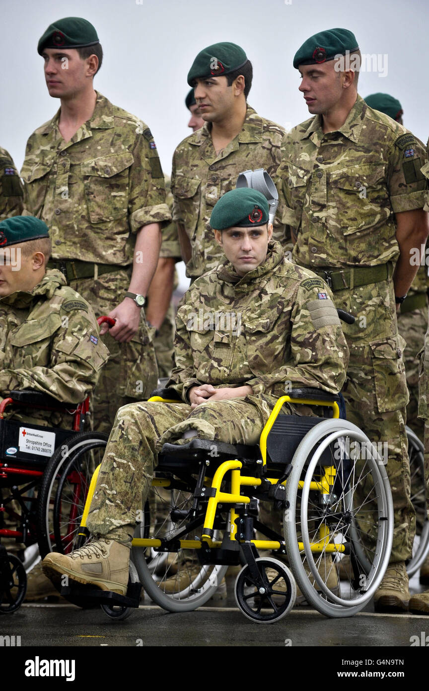 An injured soldier in a wheelchair watches the crowds during prayers ...