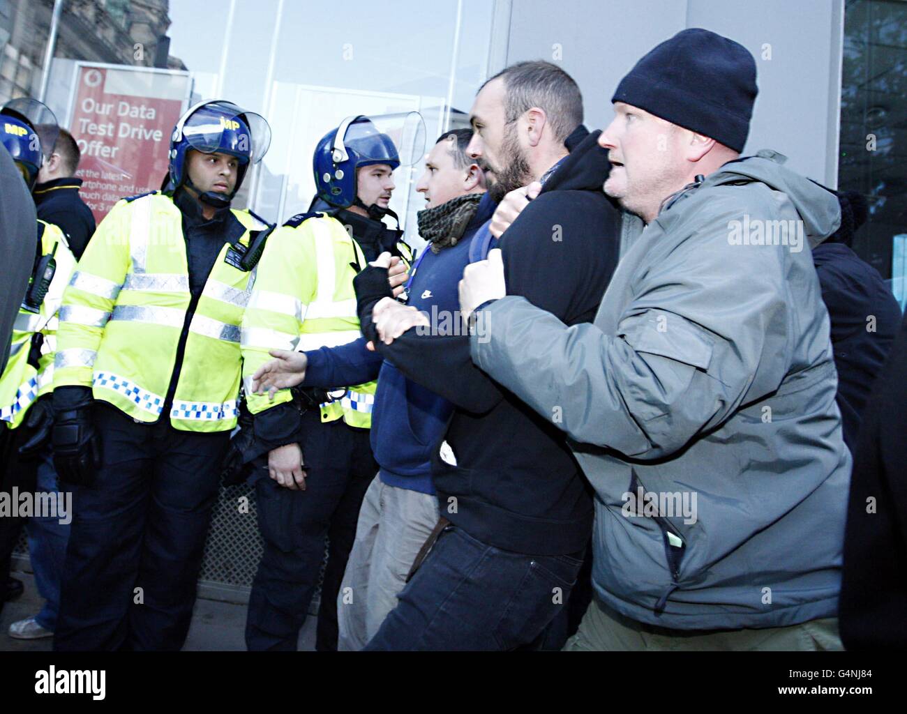 A man (centre) is led away by two plain clothes police officers in ...
