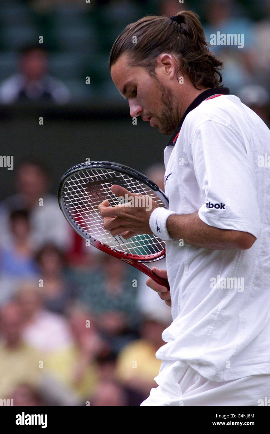 Patrick Rafter checks his racket during his match against Boris Becker ...