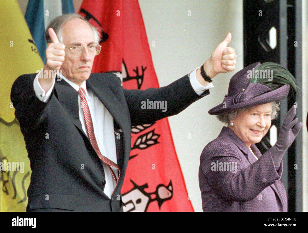 The Queen and Donald Dewar, Scottish First Minister, wave to the crowds ...
