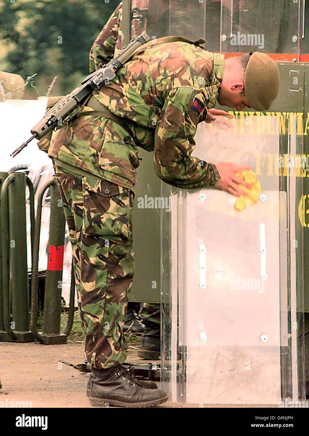 A British soldier polishes his riot shield as hundreds of troops ...