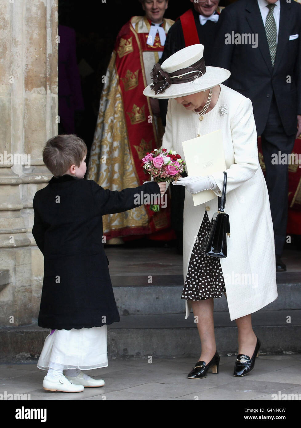Britain's Queen Elizabeth II is given some flowers by Martha Campbell ...