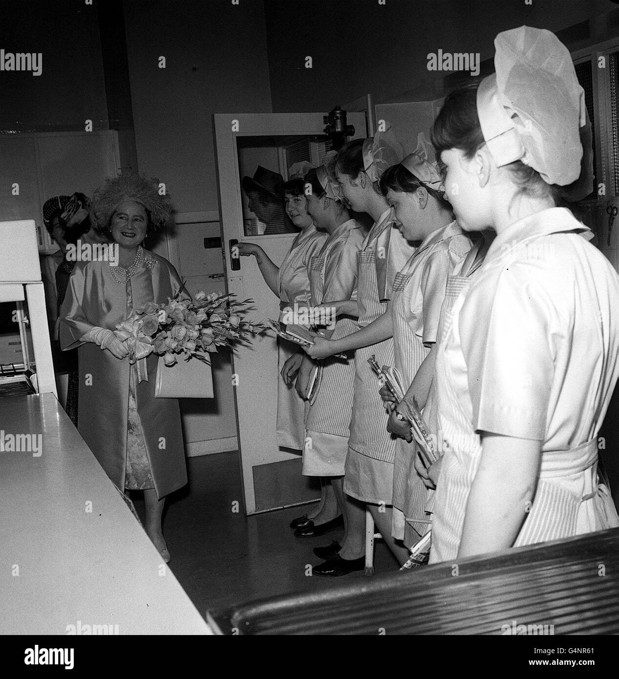 The Queen Mother inspects the demonstration kitchen, at the opening of ...
