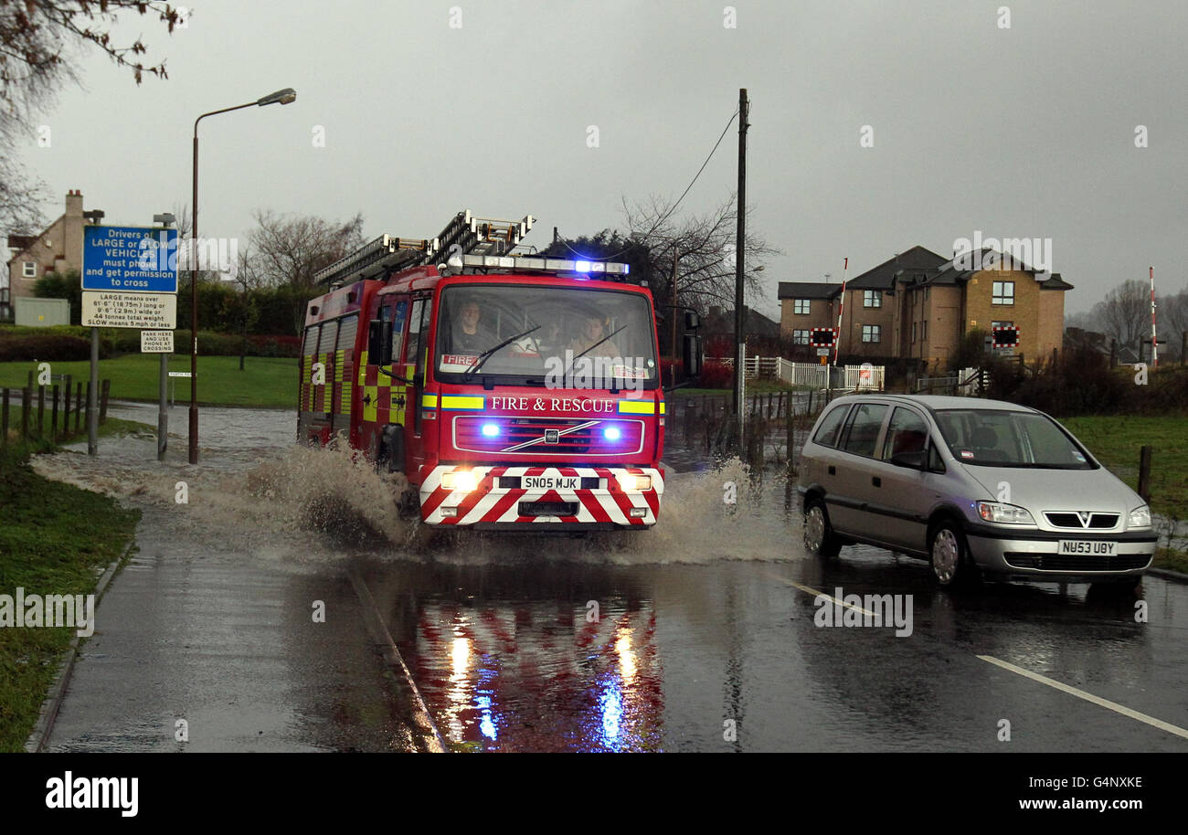 A fire engine makes its way through a flooded road due to heavy rain ...