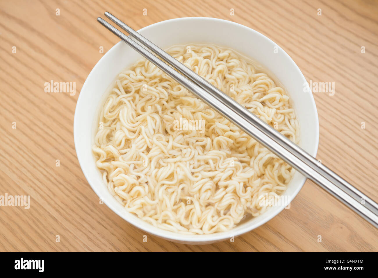 bowl of instant noodles with chopsticks on a wood table Stock Photo - Alamy