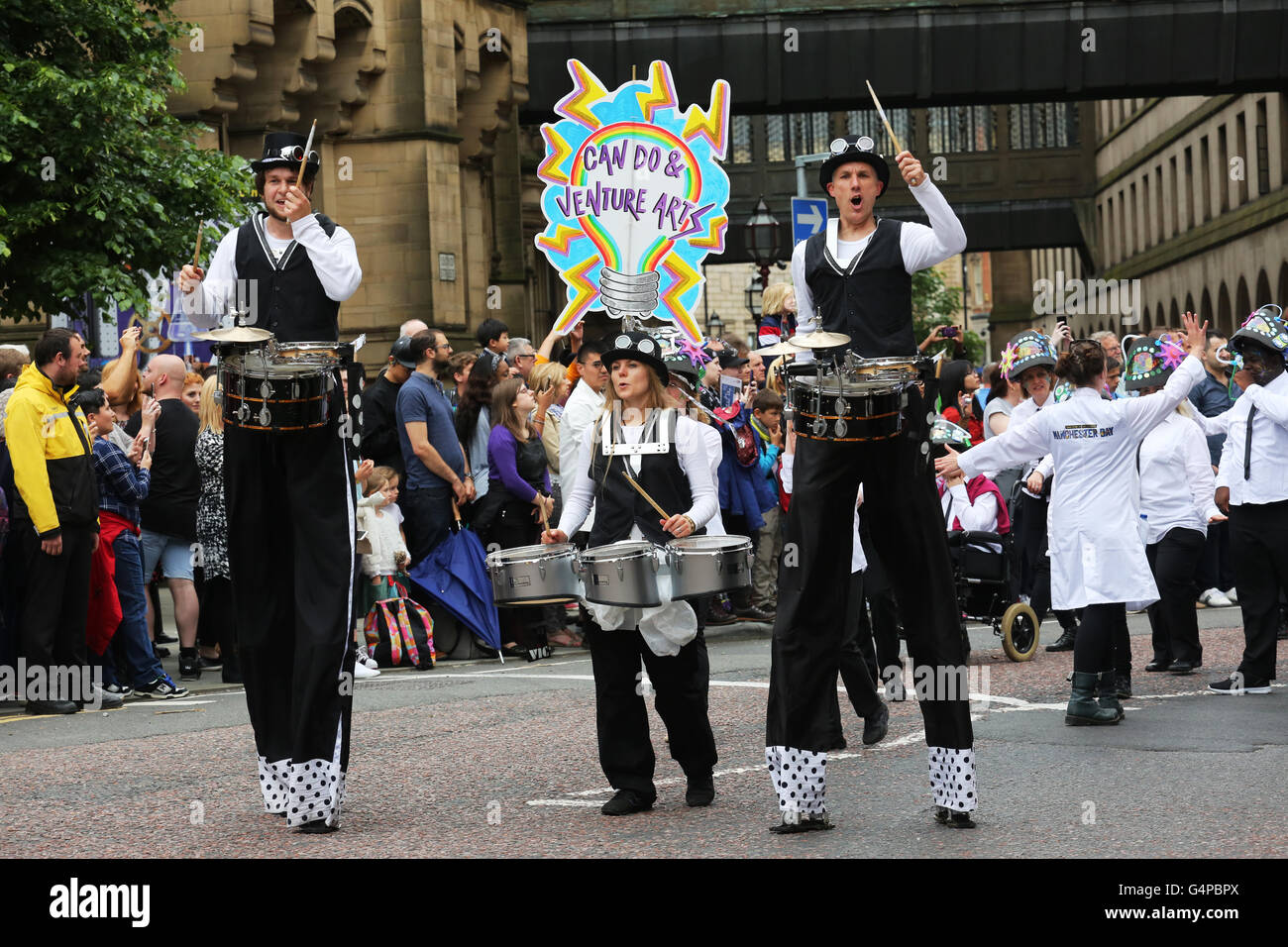 Manchester, UK. 19th June, 2016. Two men on stilts join parade through ...