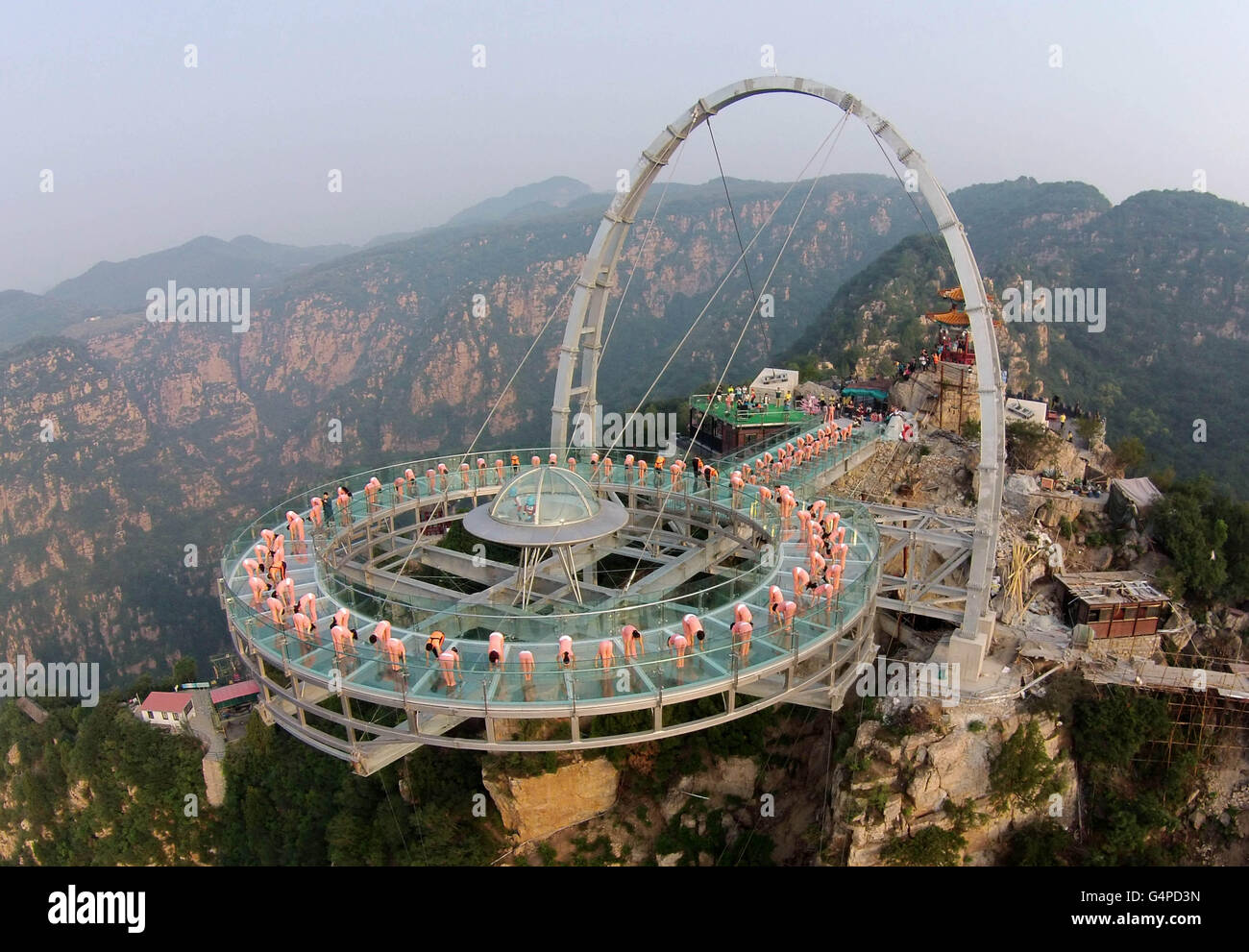 Beijing, China. 20th June, 2016. Yoga lovers practise yoga at a glass ...