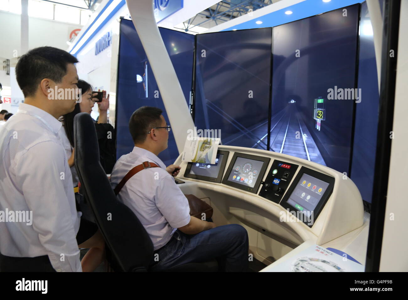 Beijing, China. 20th June, 2016. People view a driving simulator at the ...